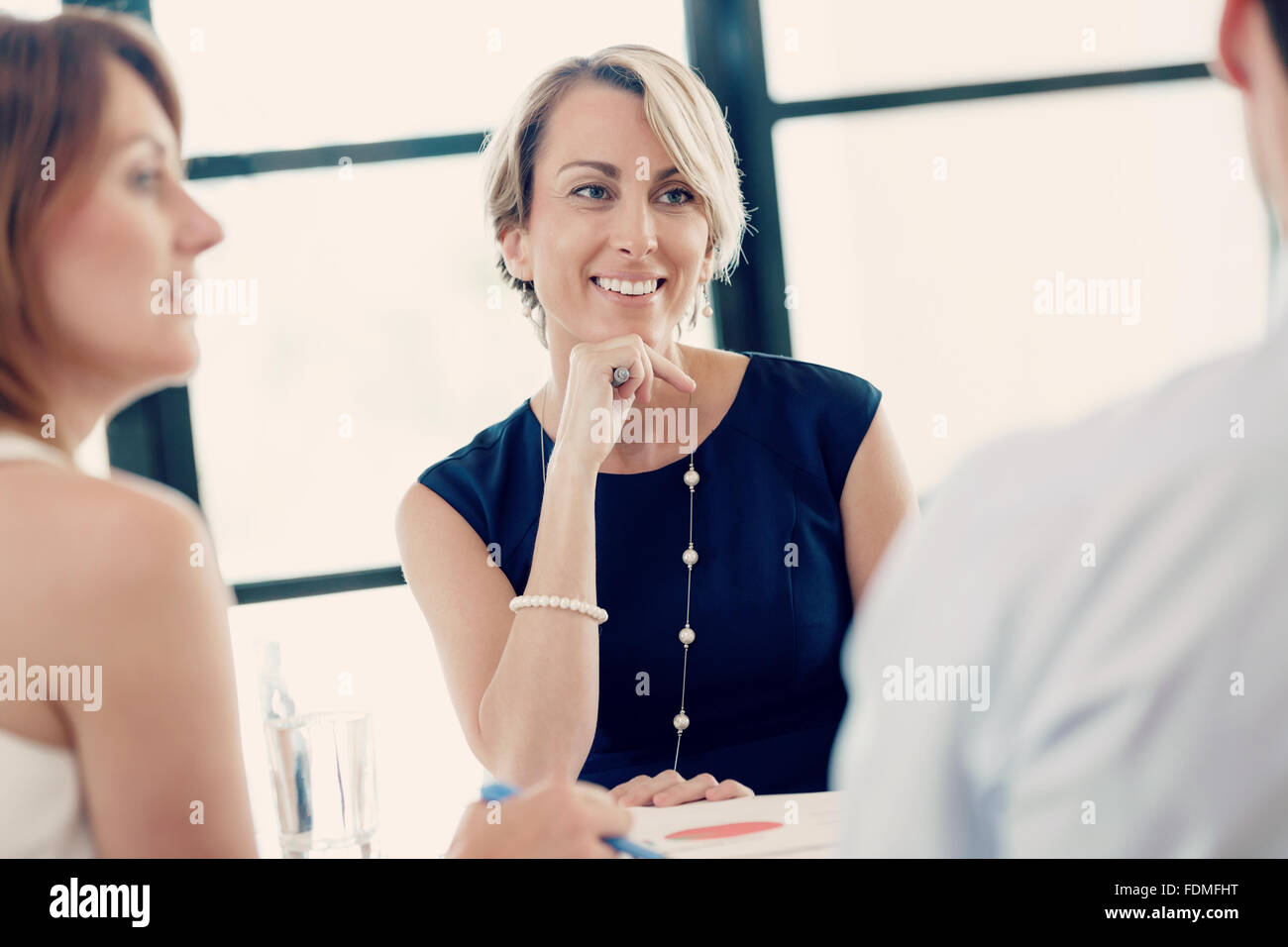 Businesswoman having discussion with collegues Stock Photo - Alamy