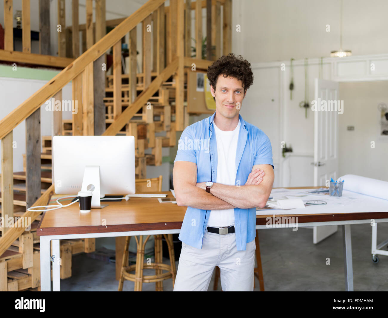 Man standing next to his desk in office Stock Photo - Alamy