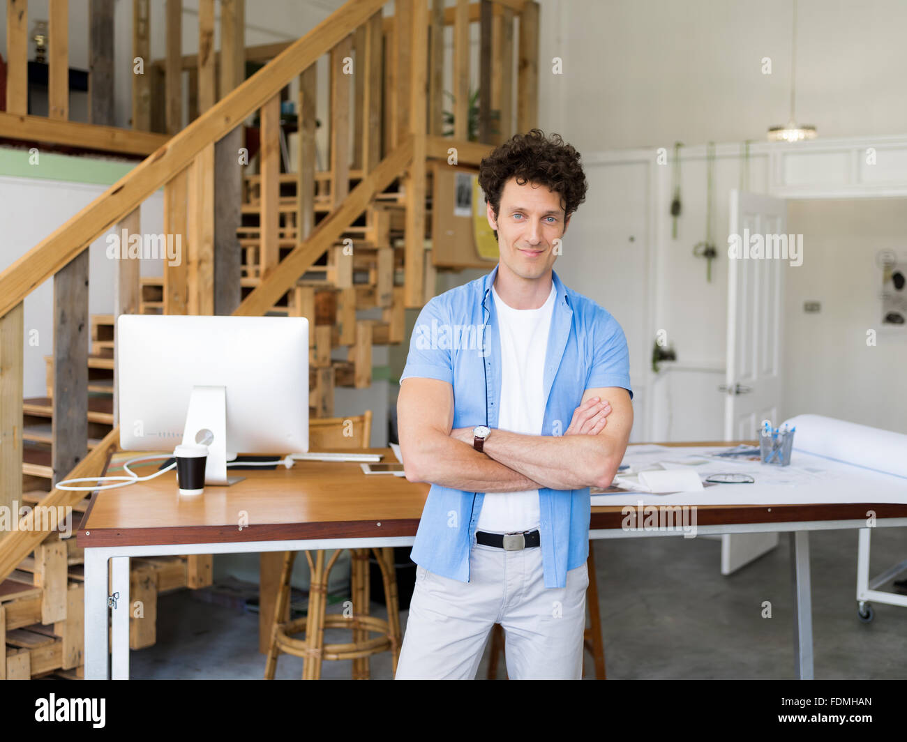 Man standing next to his desk in office Stock Photo - Alamy