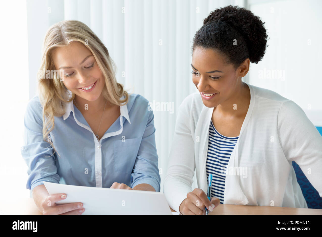 Two women working together in office Stock Photo - Alamy