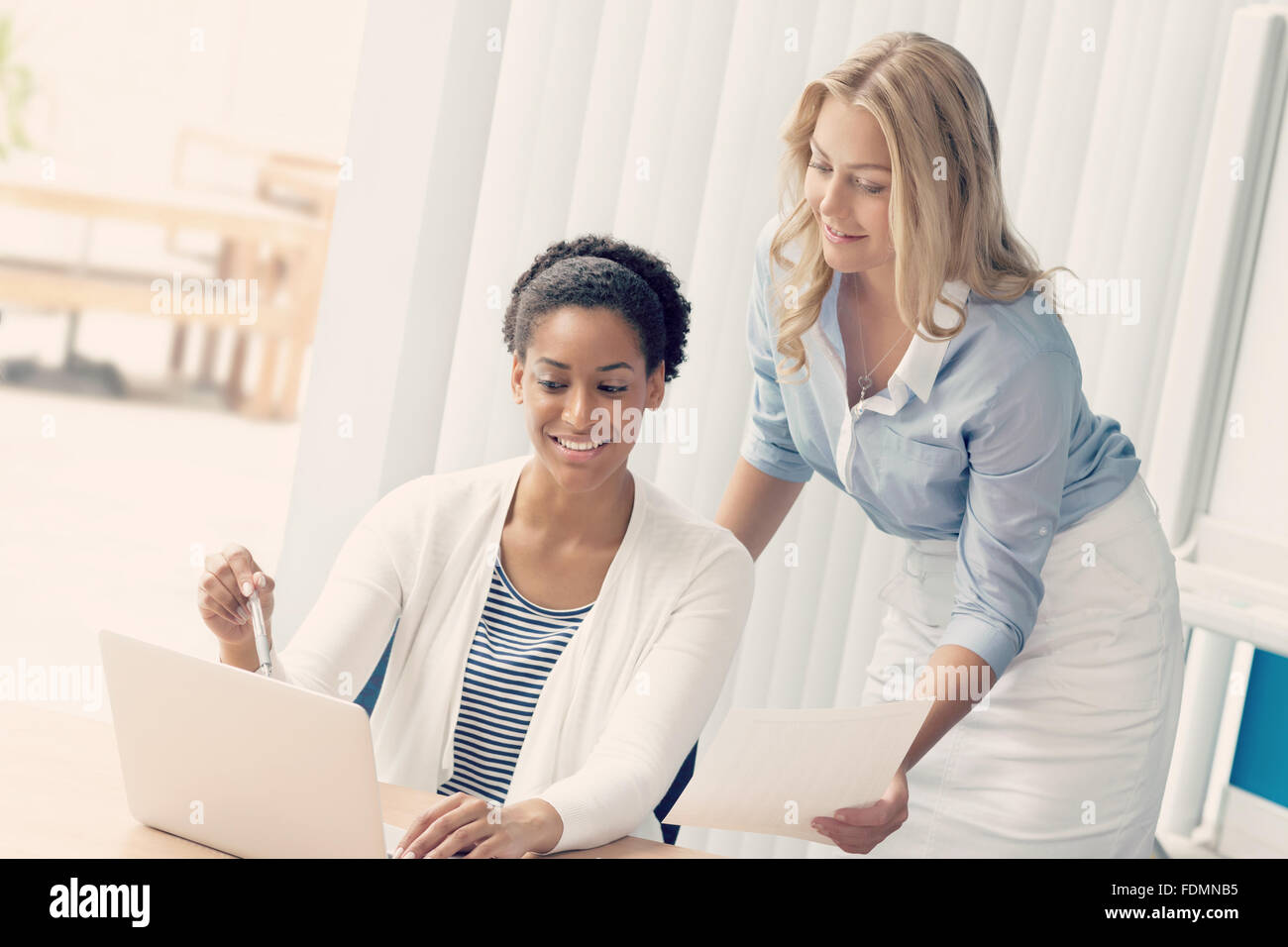 Two women working together in office Stock Photo - Alamy