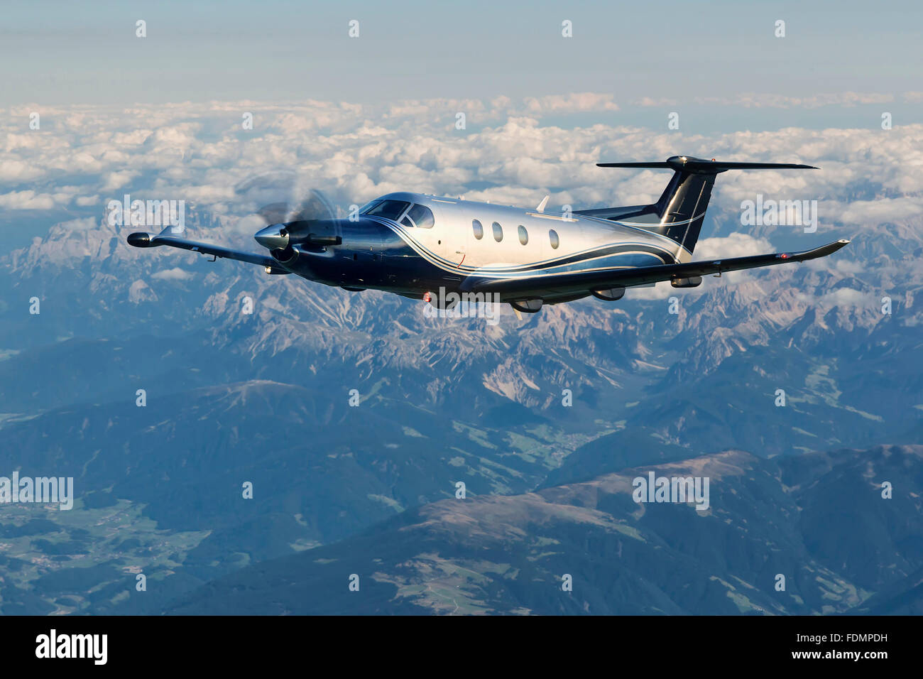 Single-engine turboprop aircraft flying over the Alps in Austria Stock ...