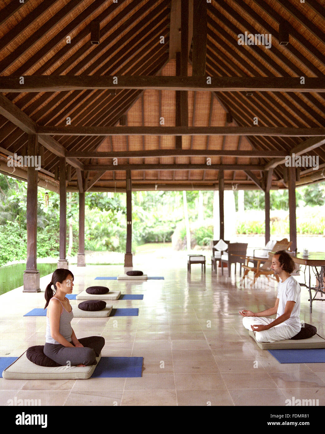 Woman and man meditating during yoga class at The Farm at San Benito ...