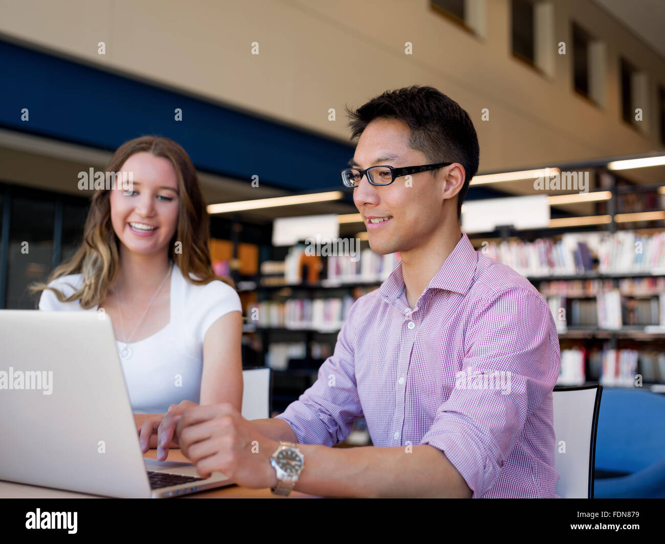 Two young students working together at the library Stock Photo - Alamy