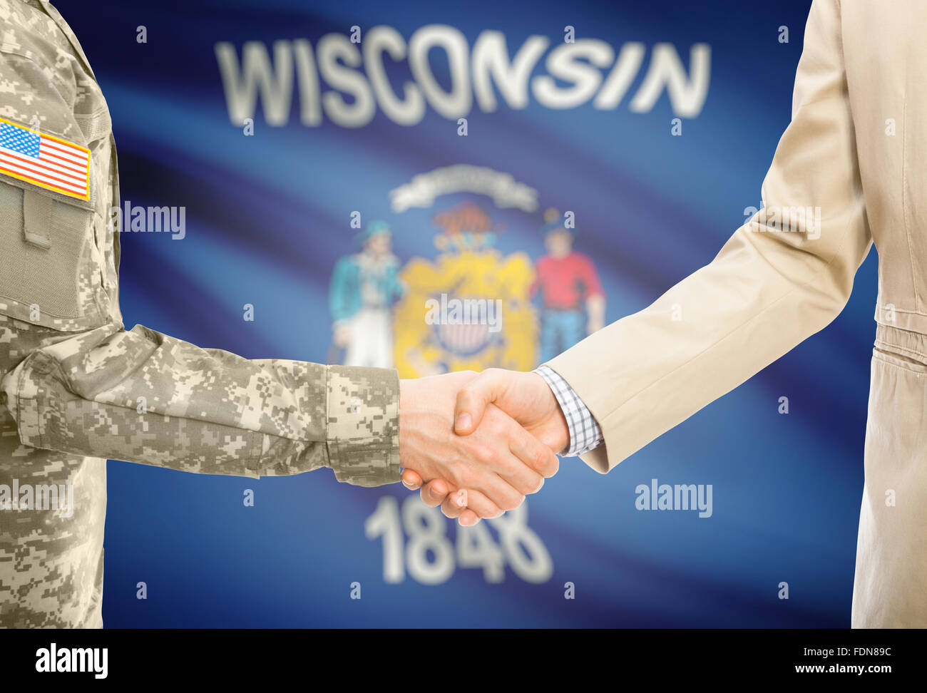 American soldier in uniform and civil man in suit shaking hands with ...