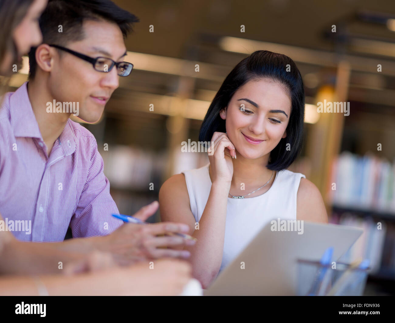 Group of young students working together at the library Stock Photo - Alamy