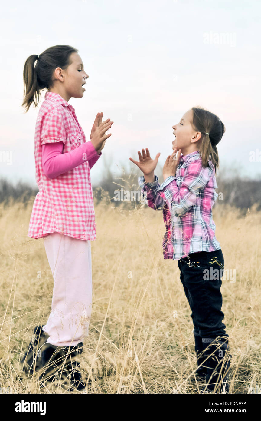 Girls in field playing hand clapping games Stock Photo - Alamy
