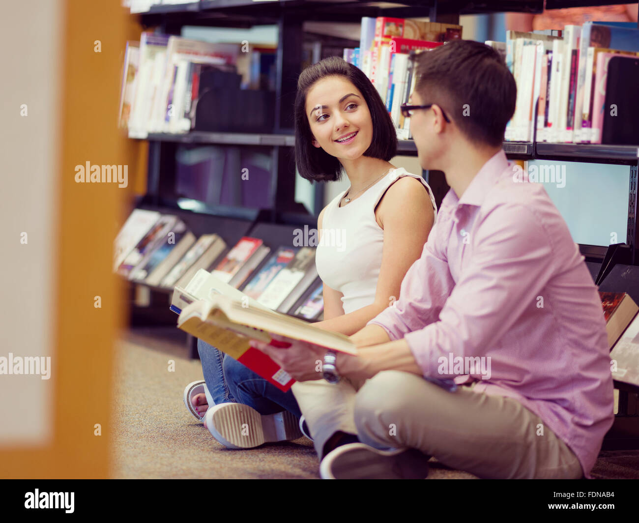 Two young students working together at the library Stock Photo - Alamy