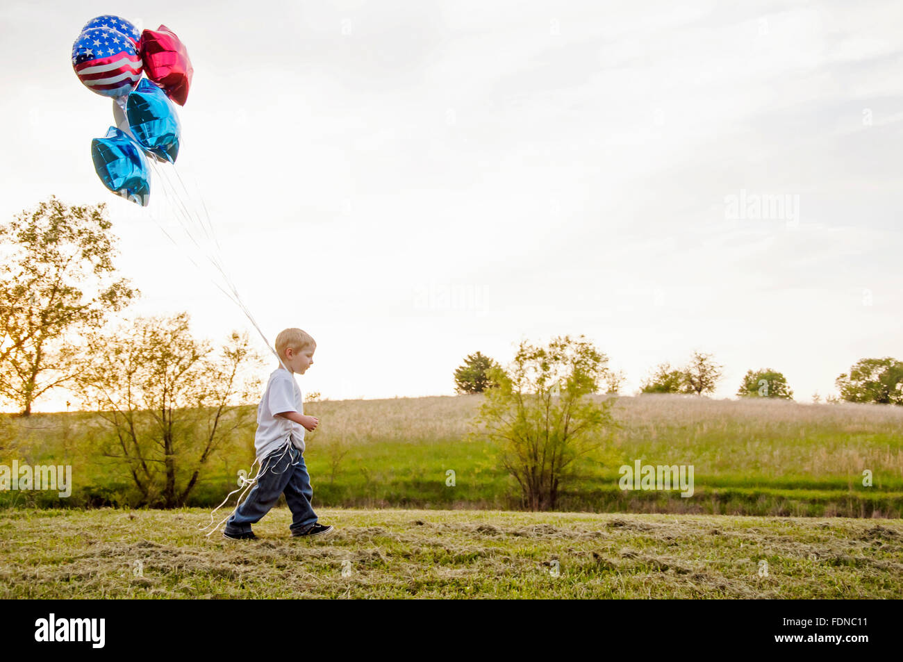 boy walking with balloons Stock Photo - Alamy