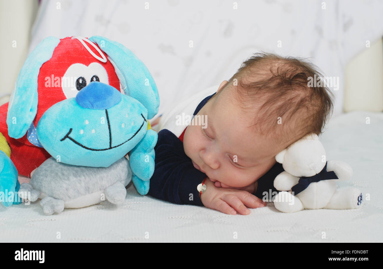 newborn baby boy sleeping with his toys Stock Photo - Alamy