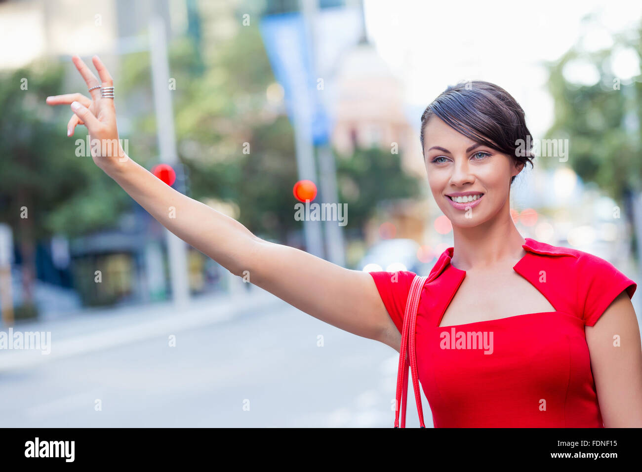 Businesswoman trying to catch a taxi in business city district Stock ...
