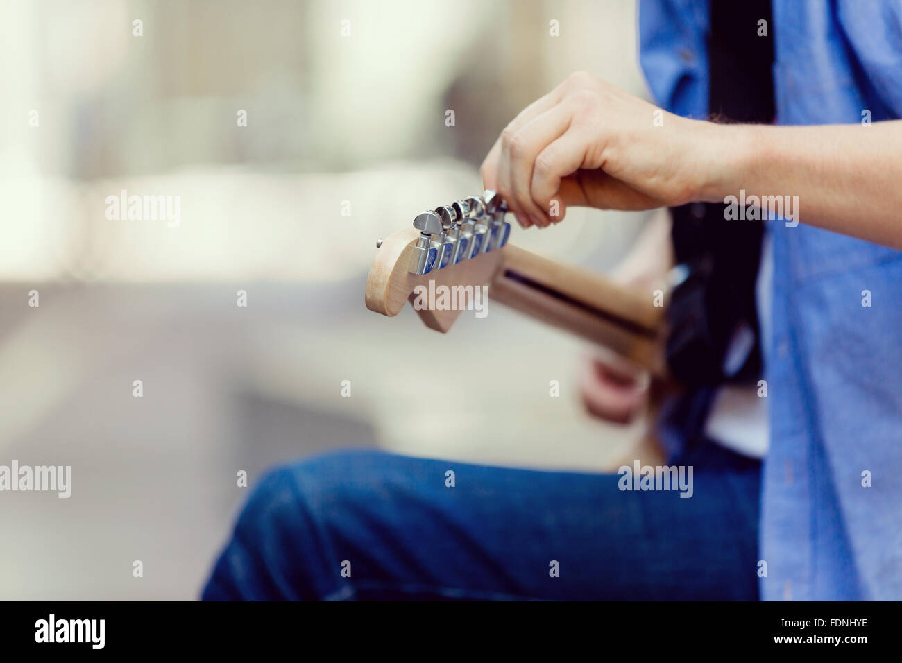 Hands of musician tuning his guitar outside Stock Photo - Alamy