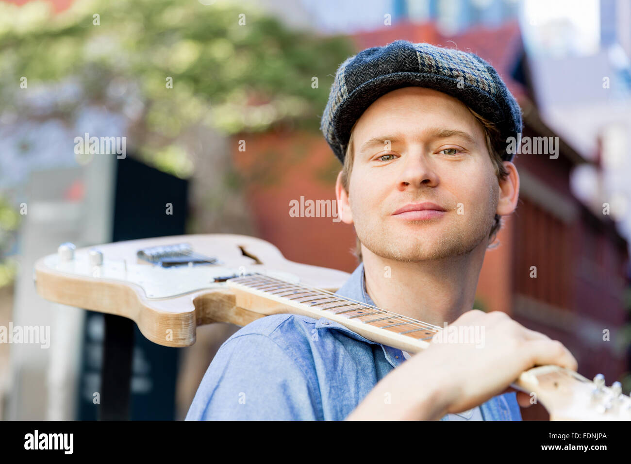 Portrait of young musician with guitar in city Stock Photo - Alamy