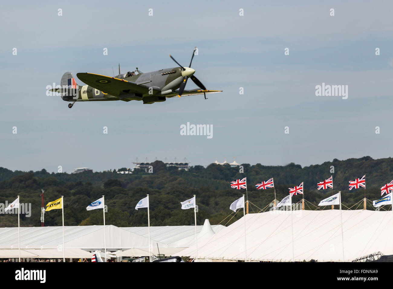 Spitfire flying over the tents at Goodwood Revival Stock Photo - Alamy