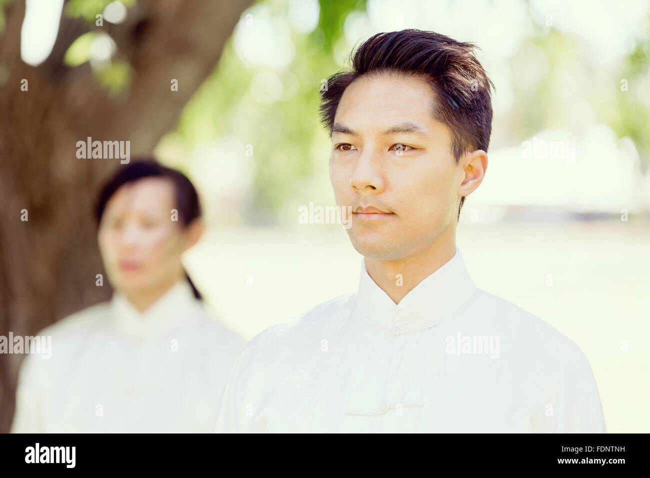Handsome man practicing thai chi in the park in the summertime Stock Photo - Alamy