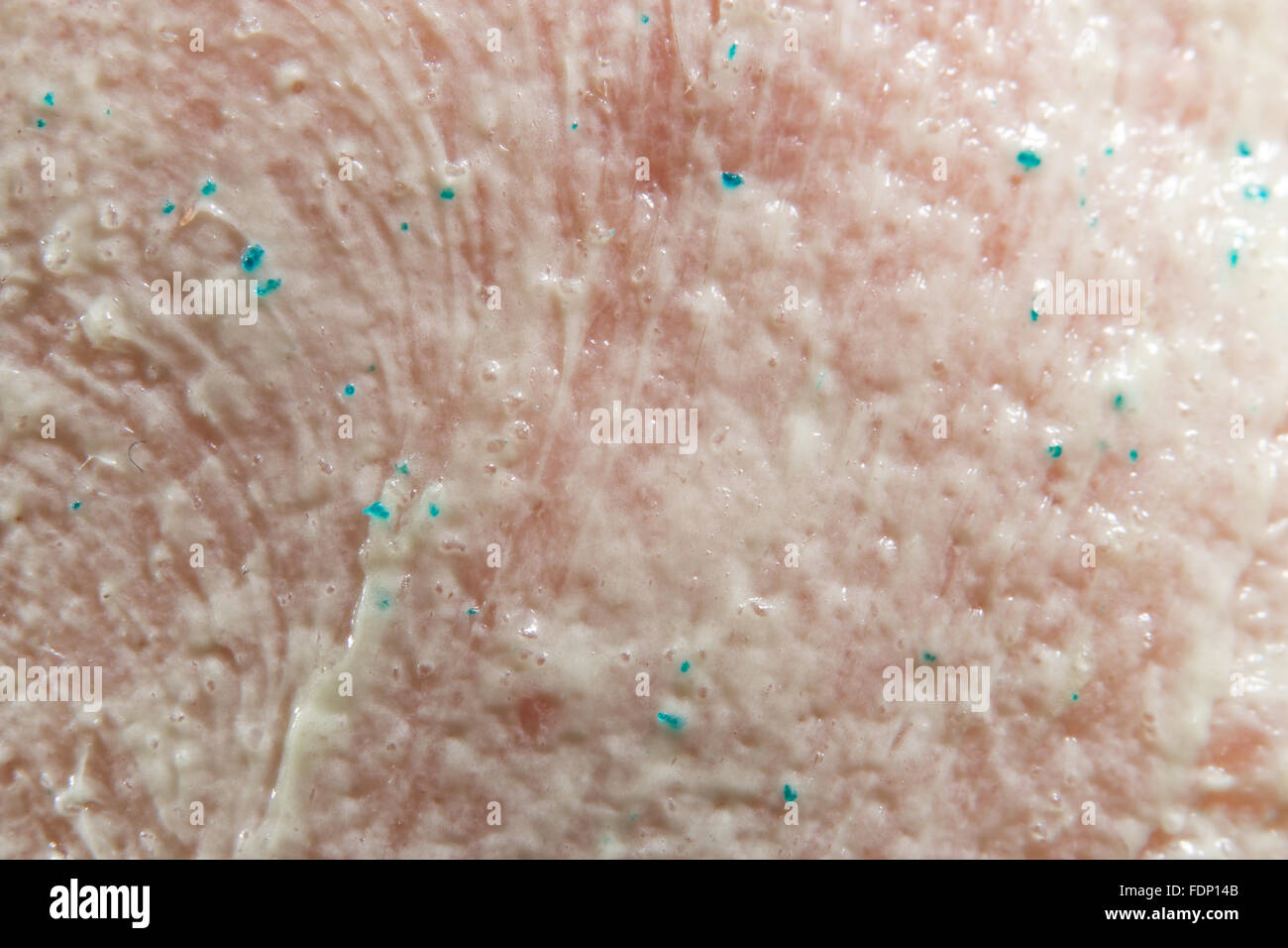 Close up of microbeads in a exfoliating face scrub rubbed into skin ...