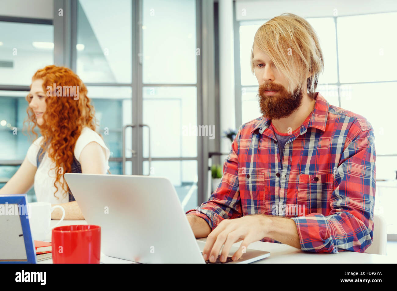 Two co-workers working together in office Stock Photo - Alamy