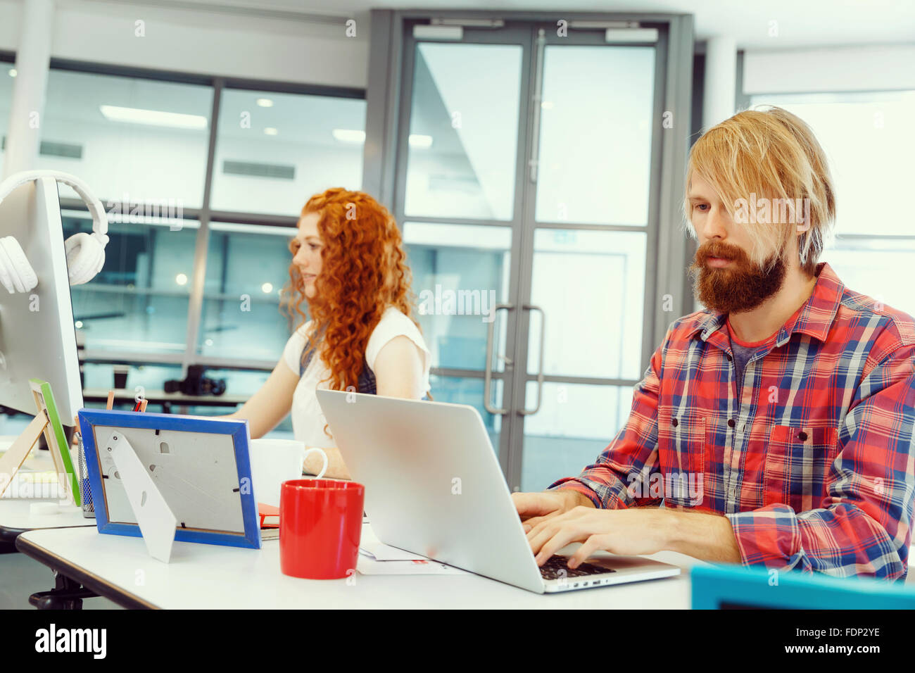 Two co-workers working together in office Stock Photo - Alamy