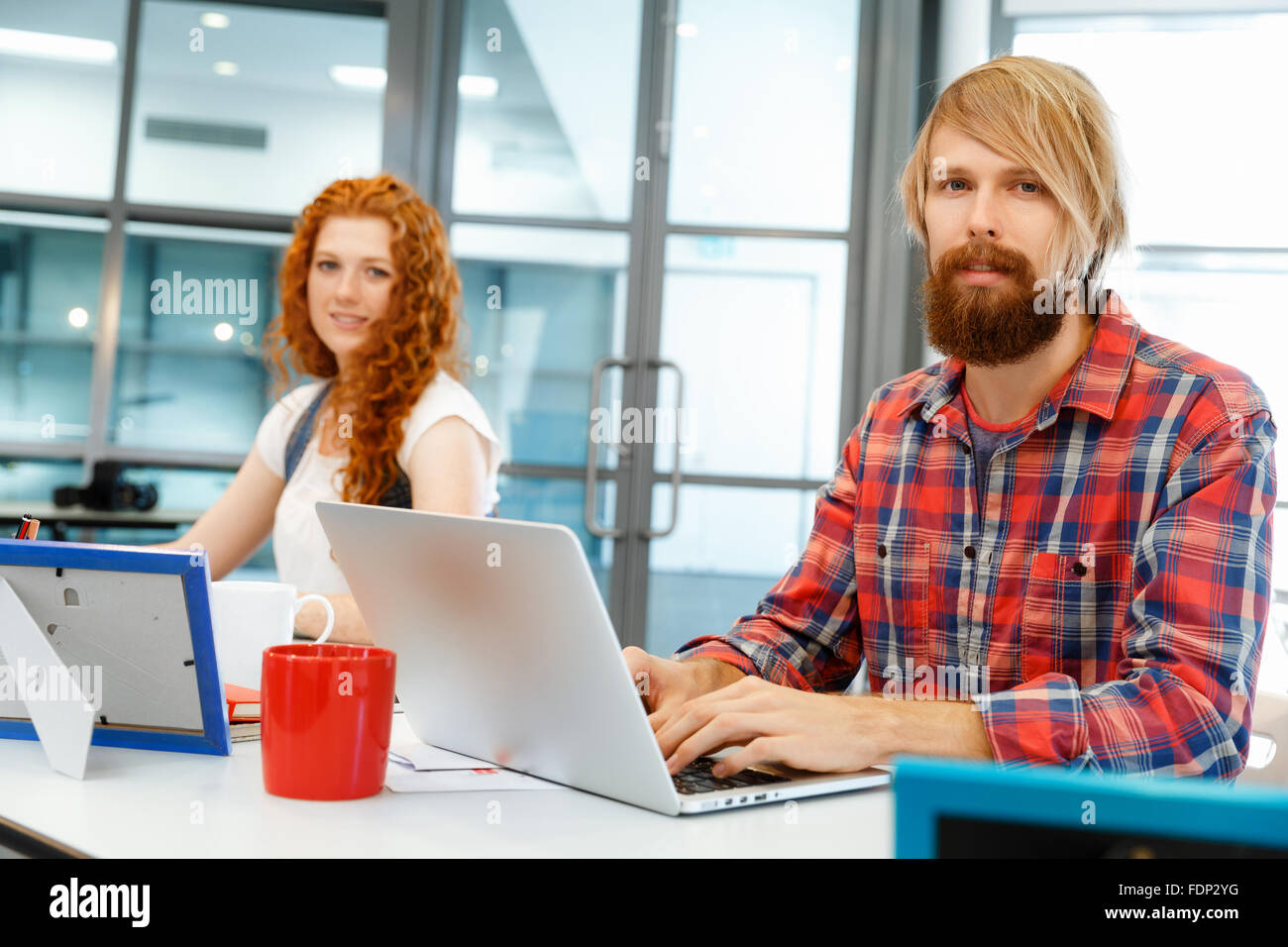 Two co-workers working together in office Stock Photo - Alamy