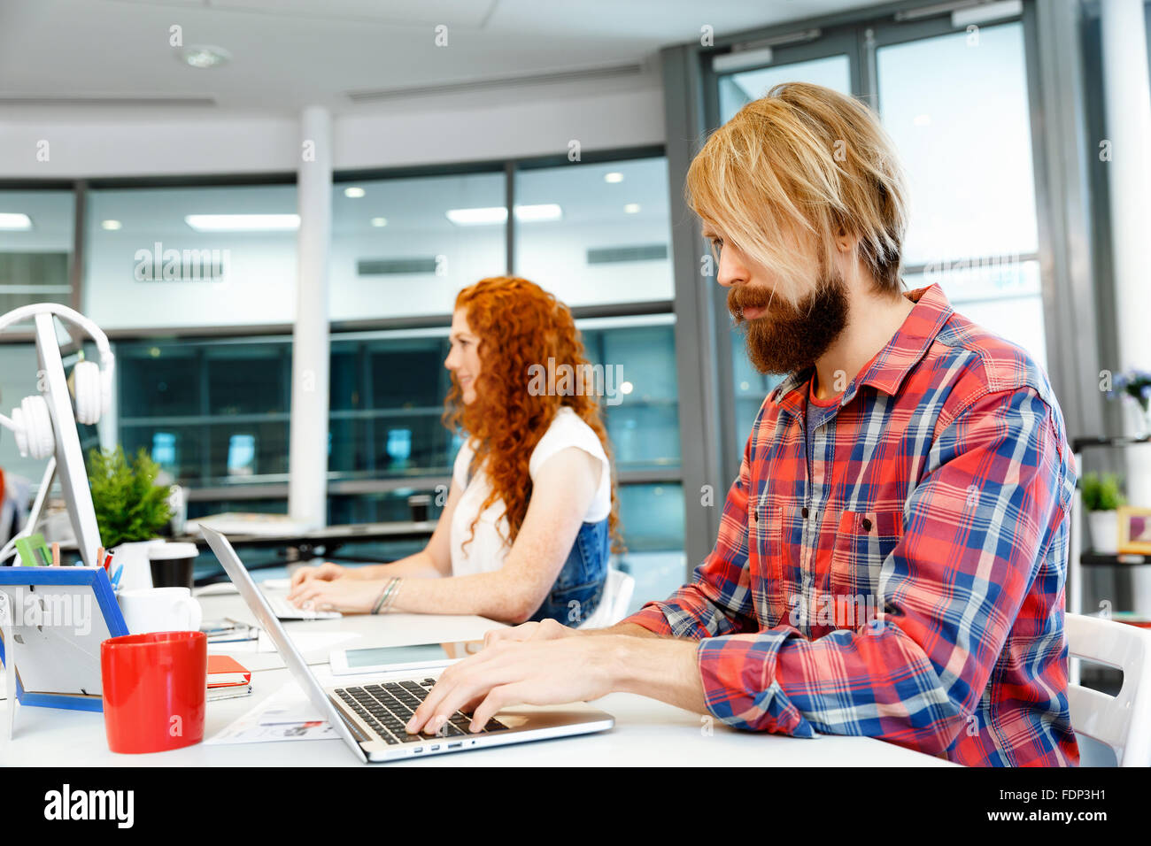 Two co-workers working together in office Stock Photo - Alamy