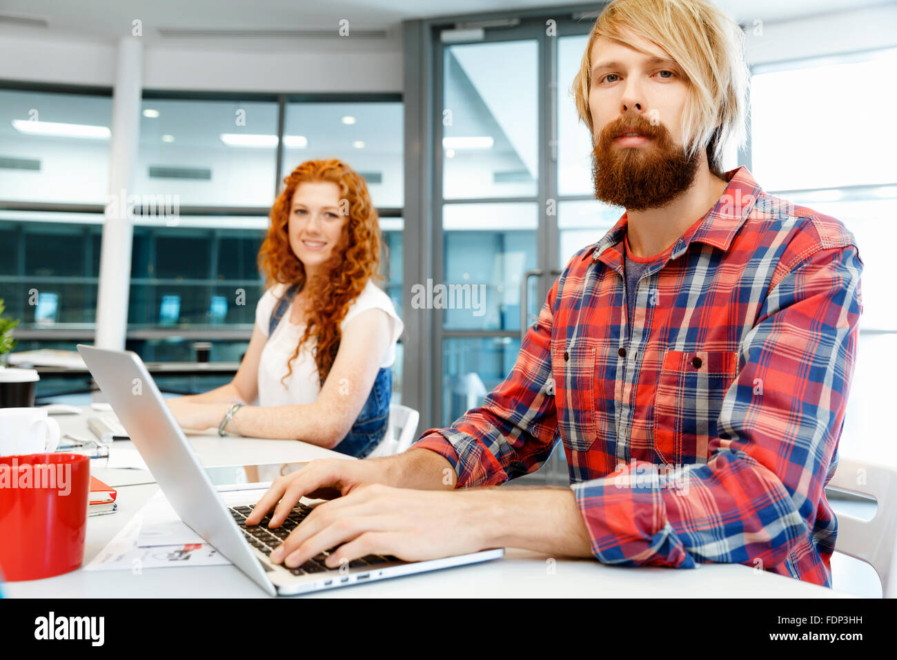 Two co-workers working together in office Stock Photo - Alamy