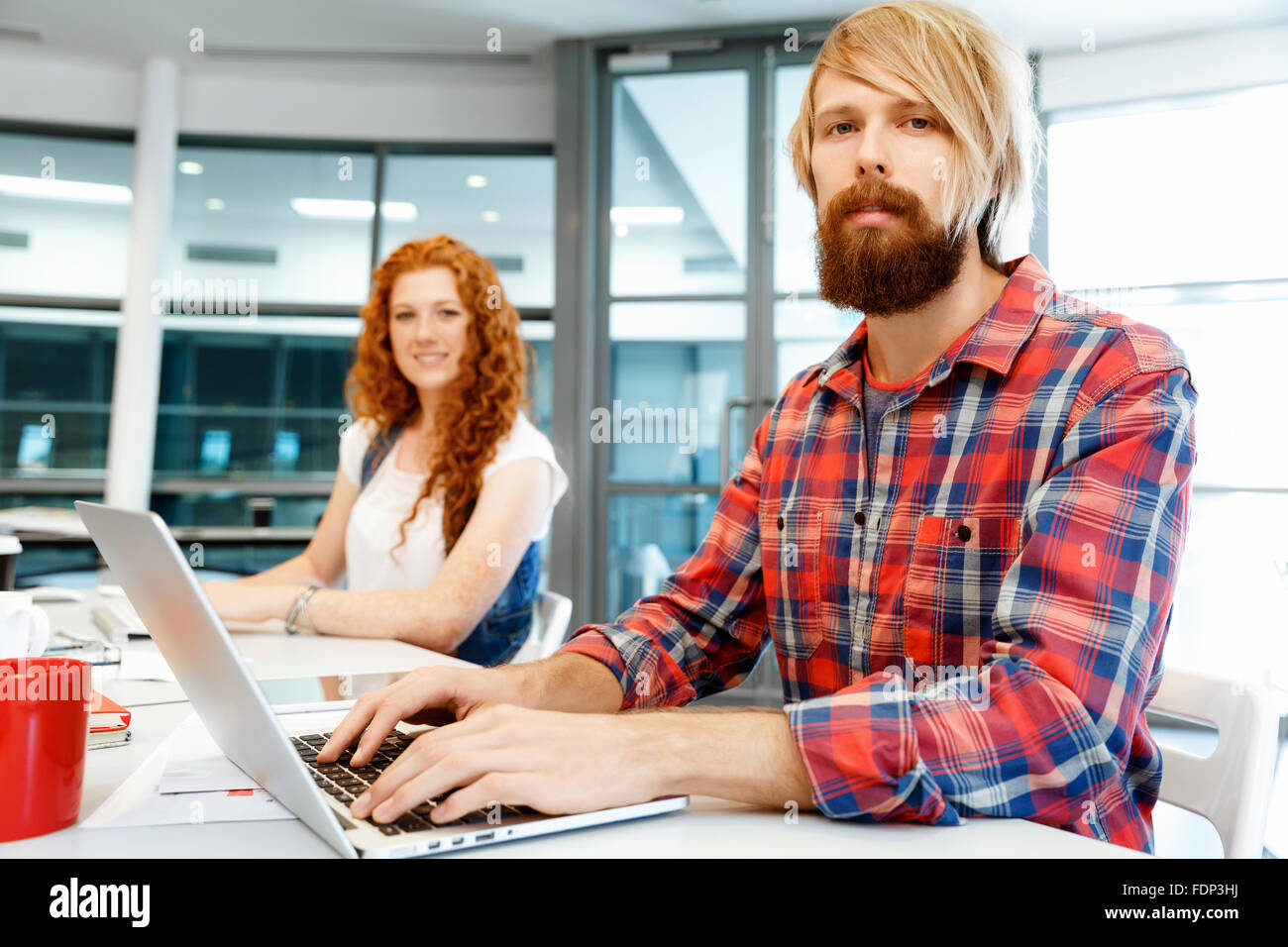 Two co-workers working together in office Stock Photo - Alamy