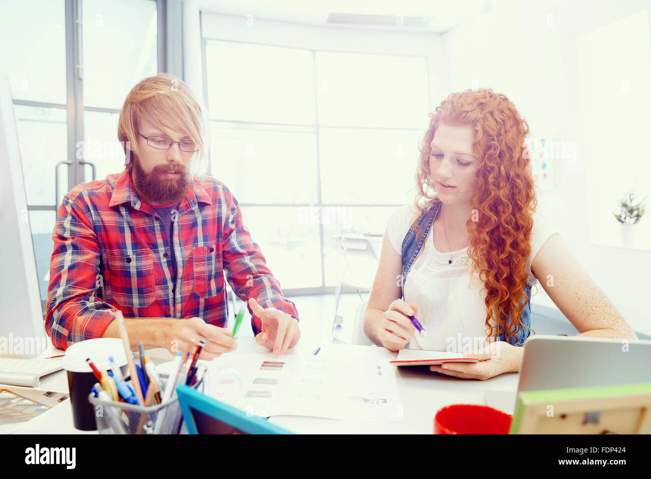 Two co-workers working together in office Stock Photo - Alamy