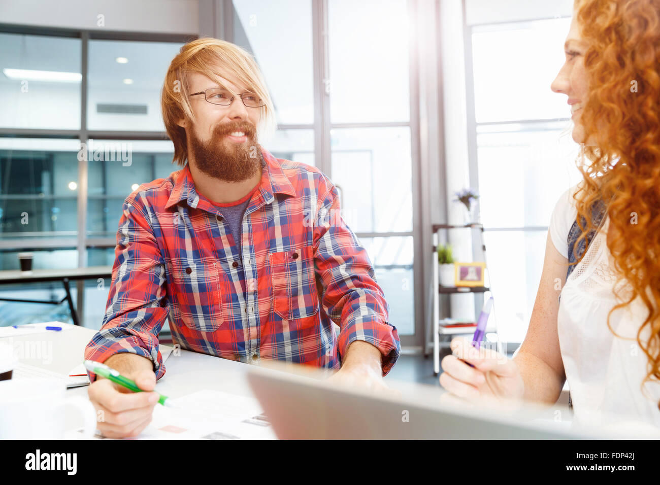Two co-workers working together in office Stock Photo - Alamy