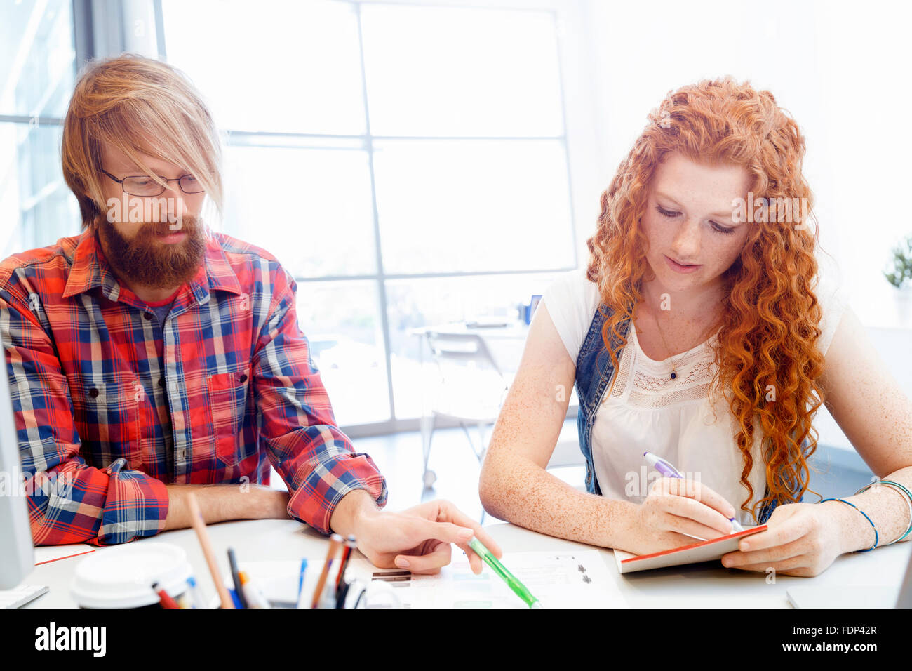 Two co-workers working together in office Stock Photo - Alamy