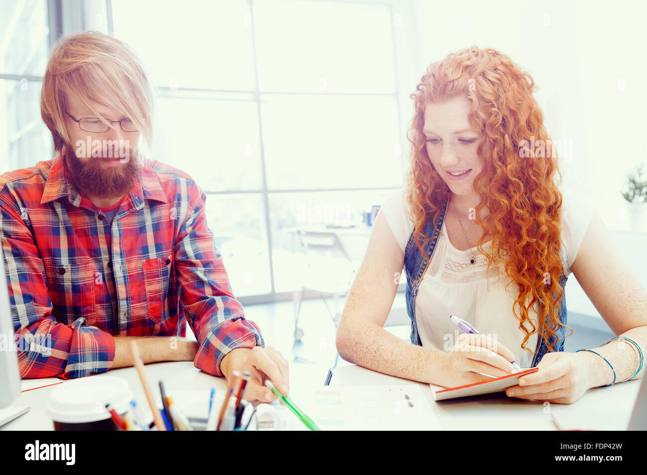 Two co-workers working together in office Stock Photo - Alamy