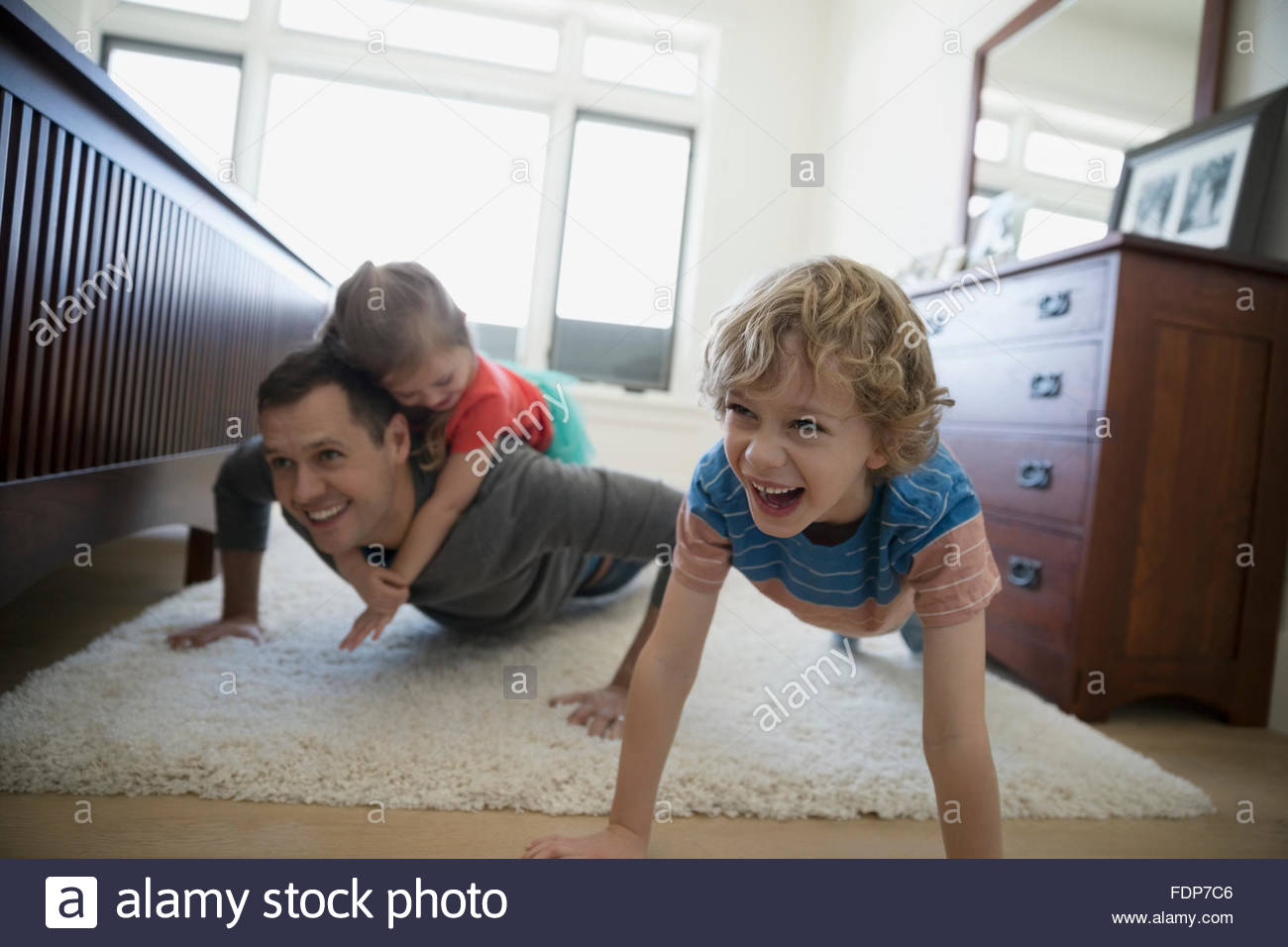 Father and children doing push-ups bedroom rug Stock Photo - Alamy