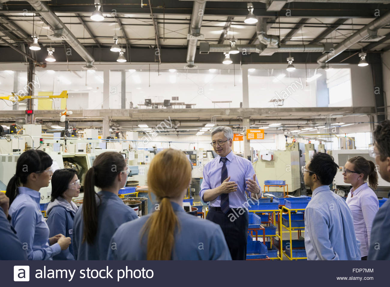 Manager leading team meeting in factory Stock Photo - Alamy