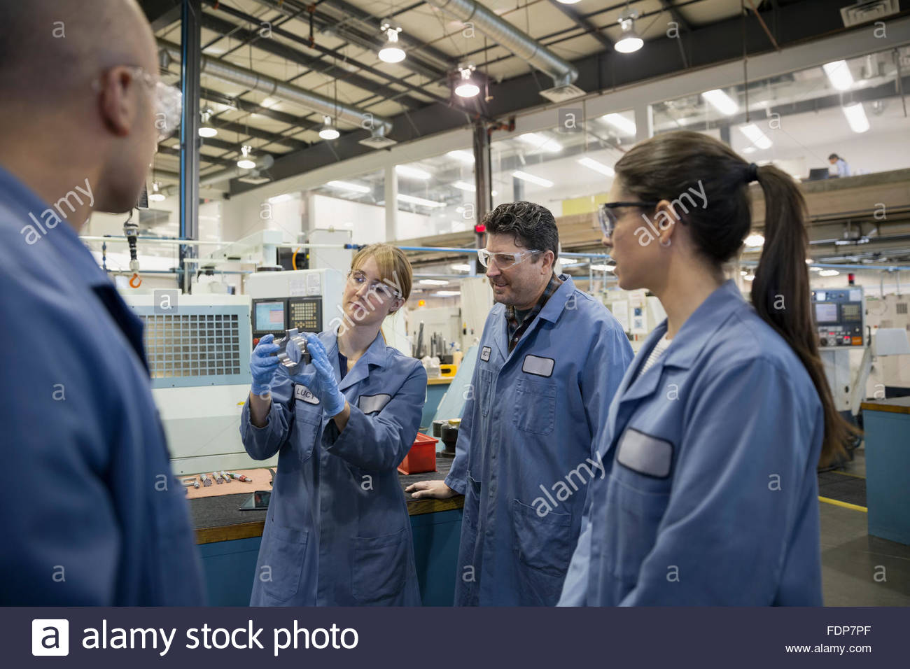 Workers discussing part in factory Stock Photo - Alamy