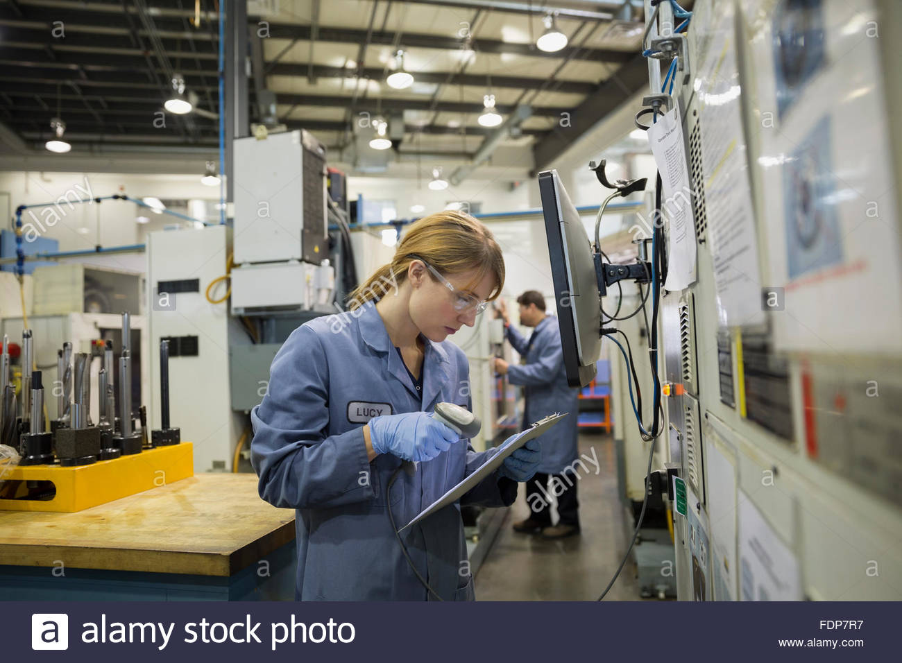 Worker scanning paperwork on clipboard in factory Stock Photo - Alamy