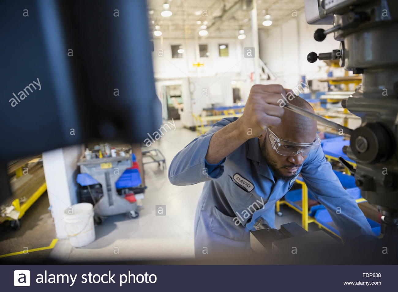 Worker using machinery in factory Stock Photo - Alamy
