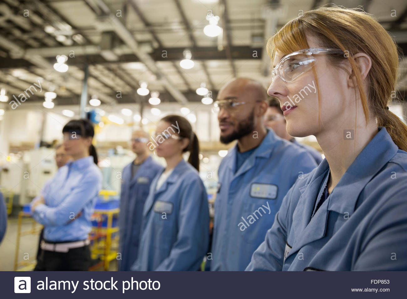 Attentive workers listening in factory meeting Stock Photo - Alamy