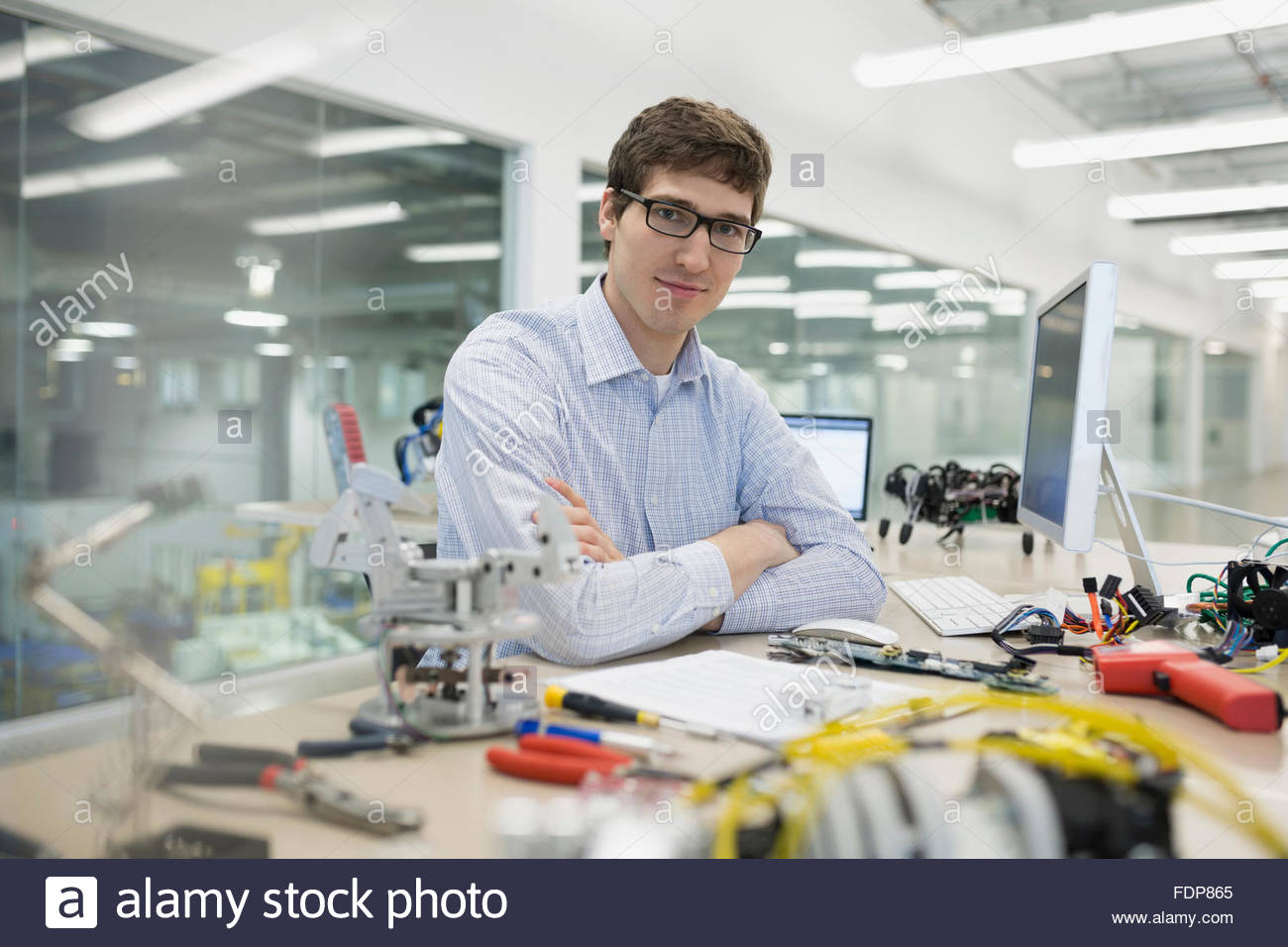 Portrait confident engineer at desk with robotics Stock Photo - Alamy