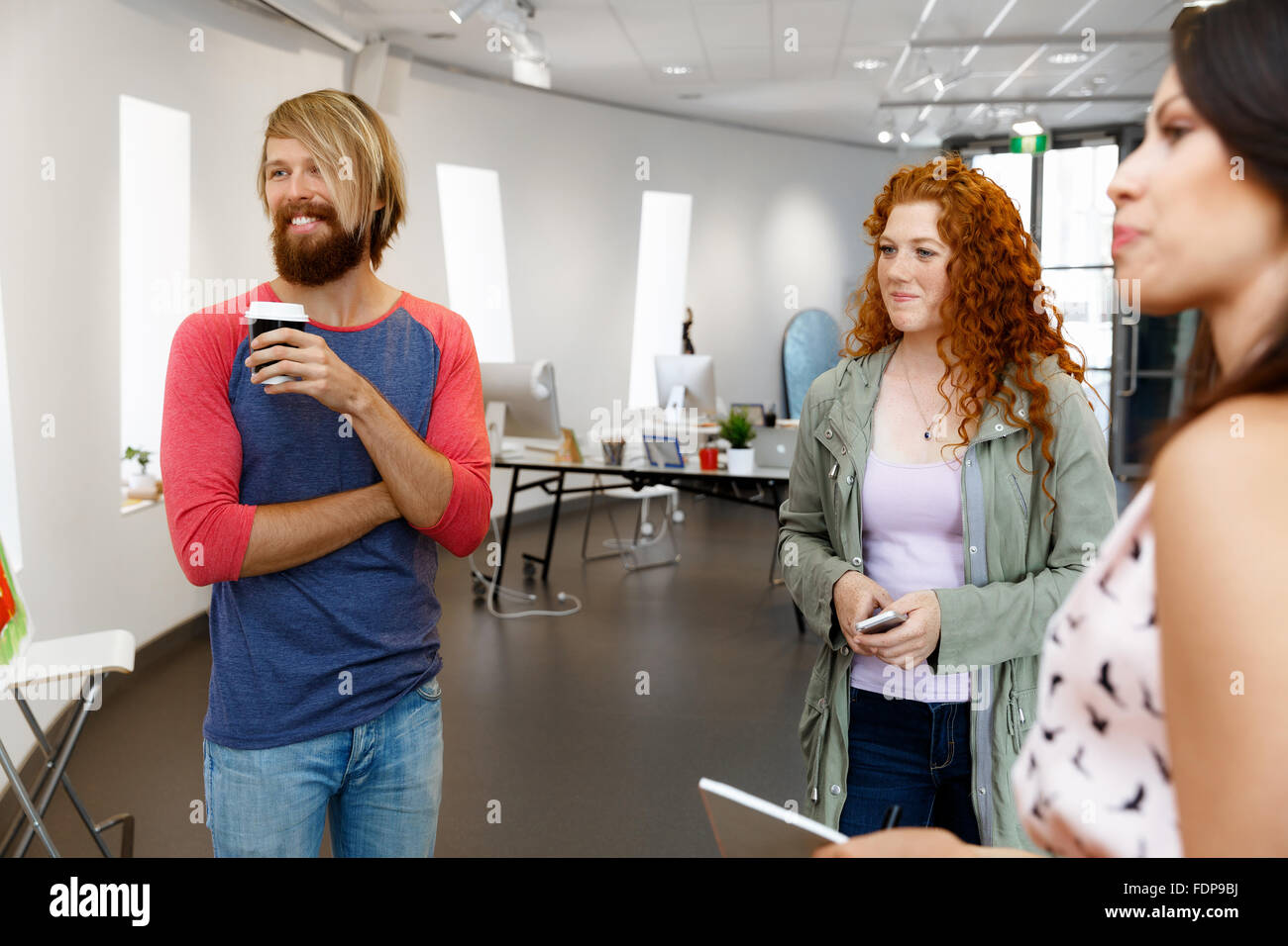 Young people standing in a gallery and contemplating abstract artwork ...