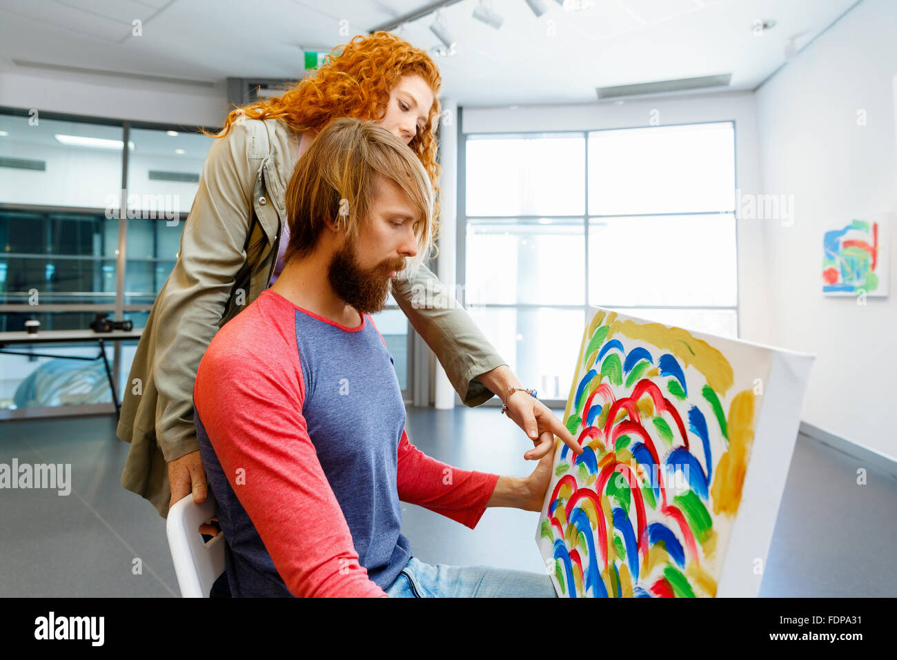 Young caucasian couple standing in a gallery and contemplating abstract ...
