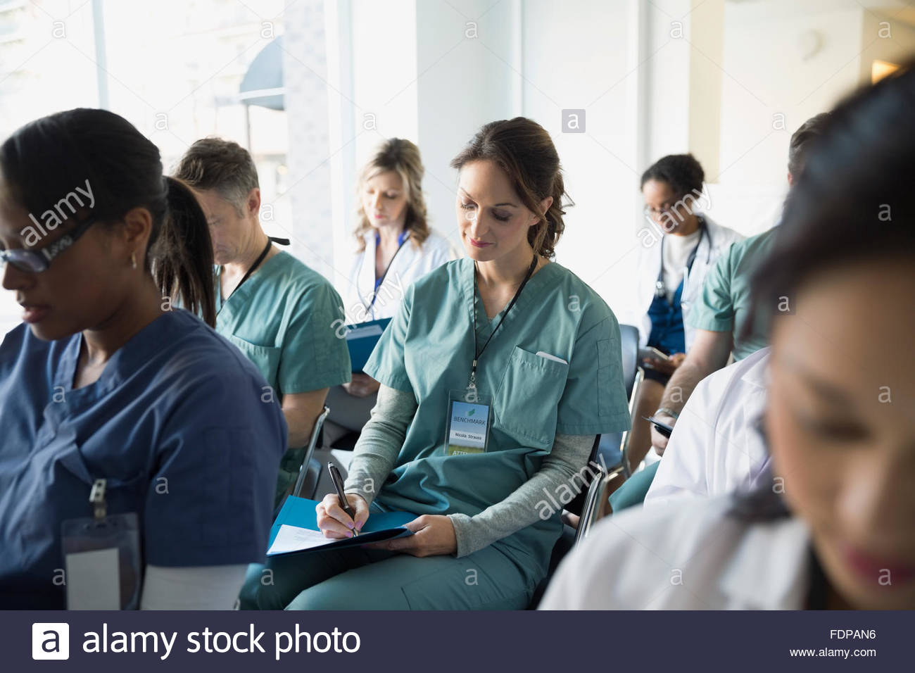 Nurse taking notes in seminar audience Stock Photo - Alamy