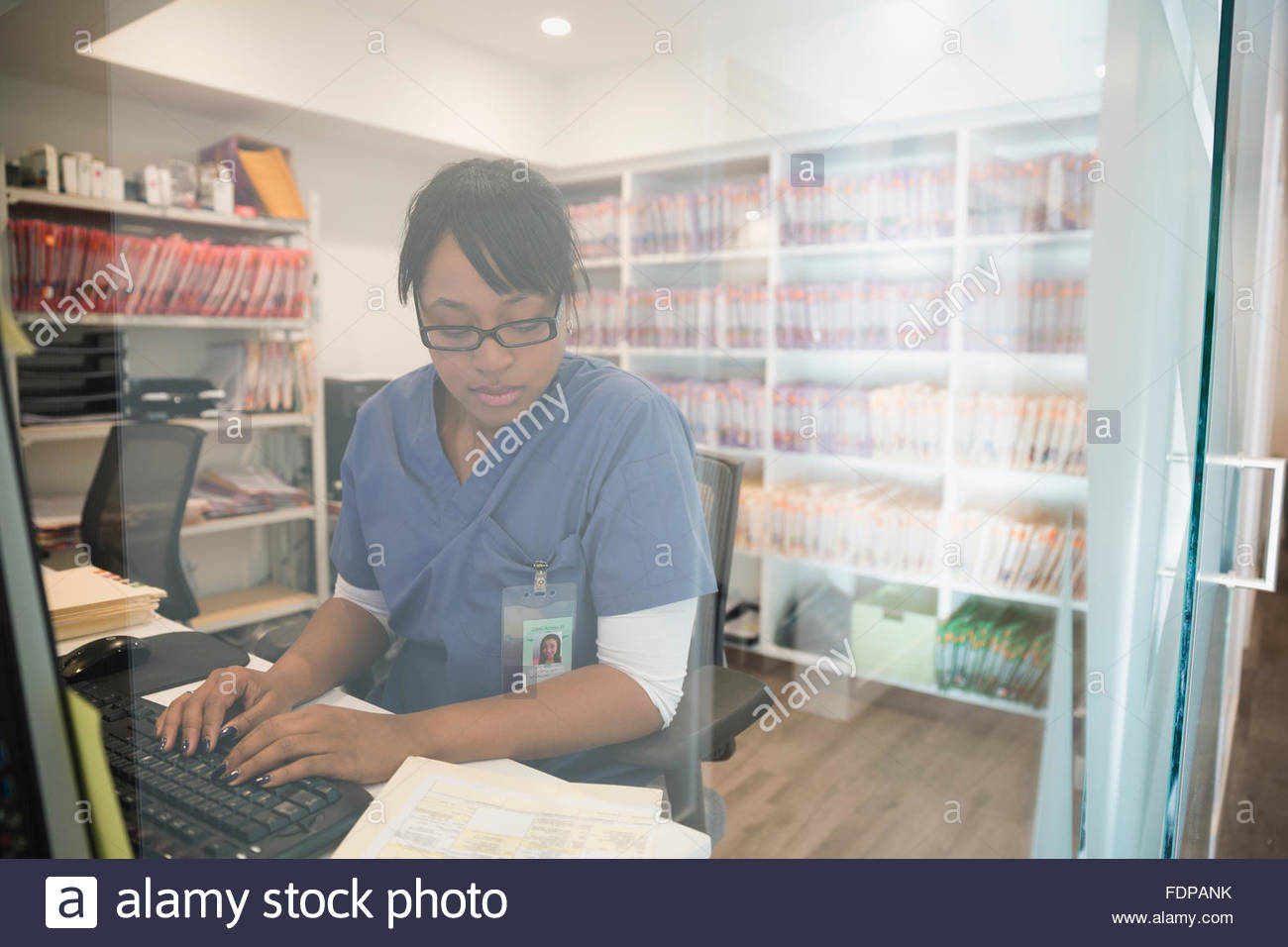 Nurse typing medical record notes at computer Stock Photo - Alamy