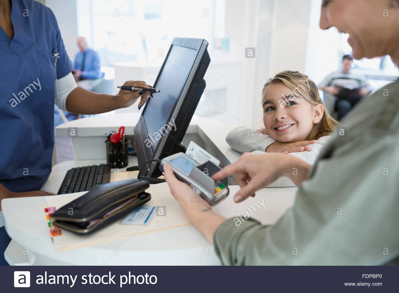 Patient using credit card reader in clinic Stock Photo - Alamy