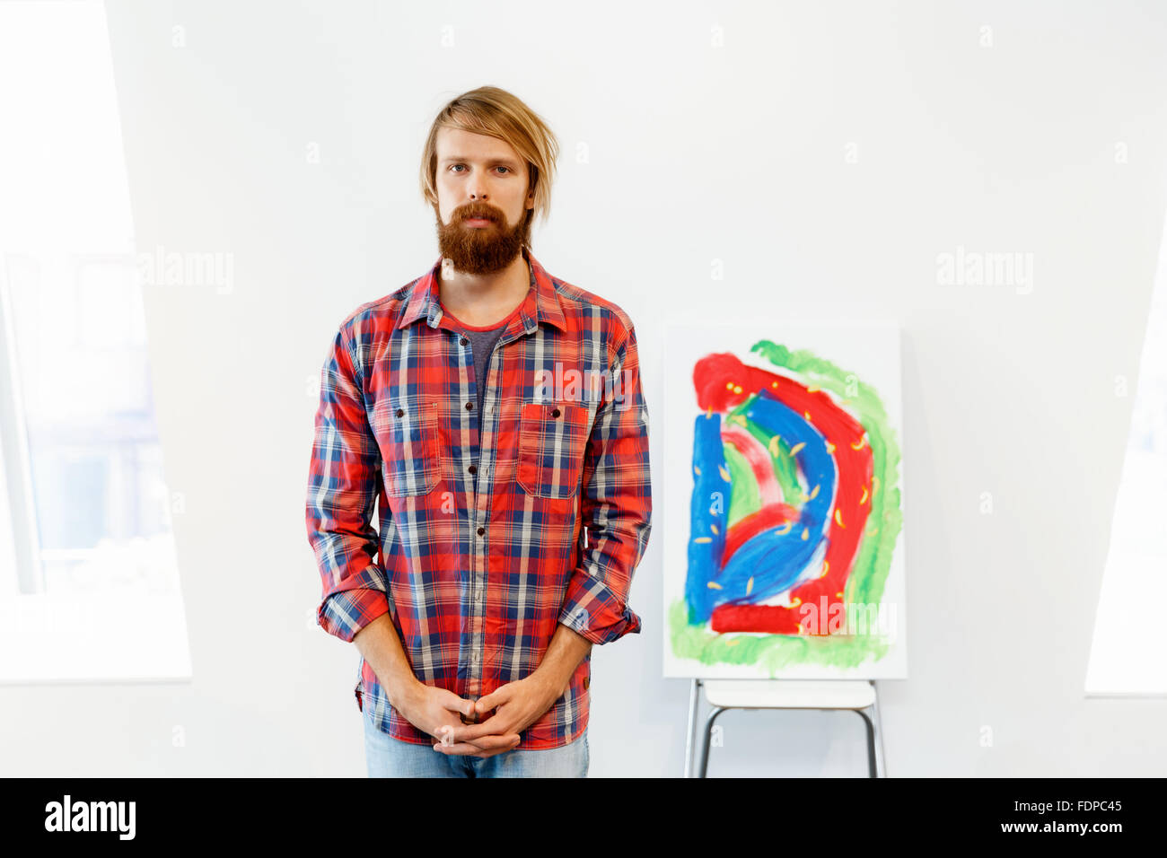 Young male artist standing with his picture Stock Photo - Alamy