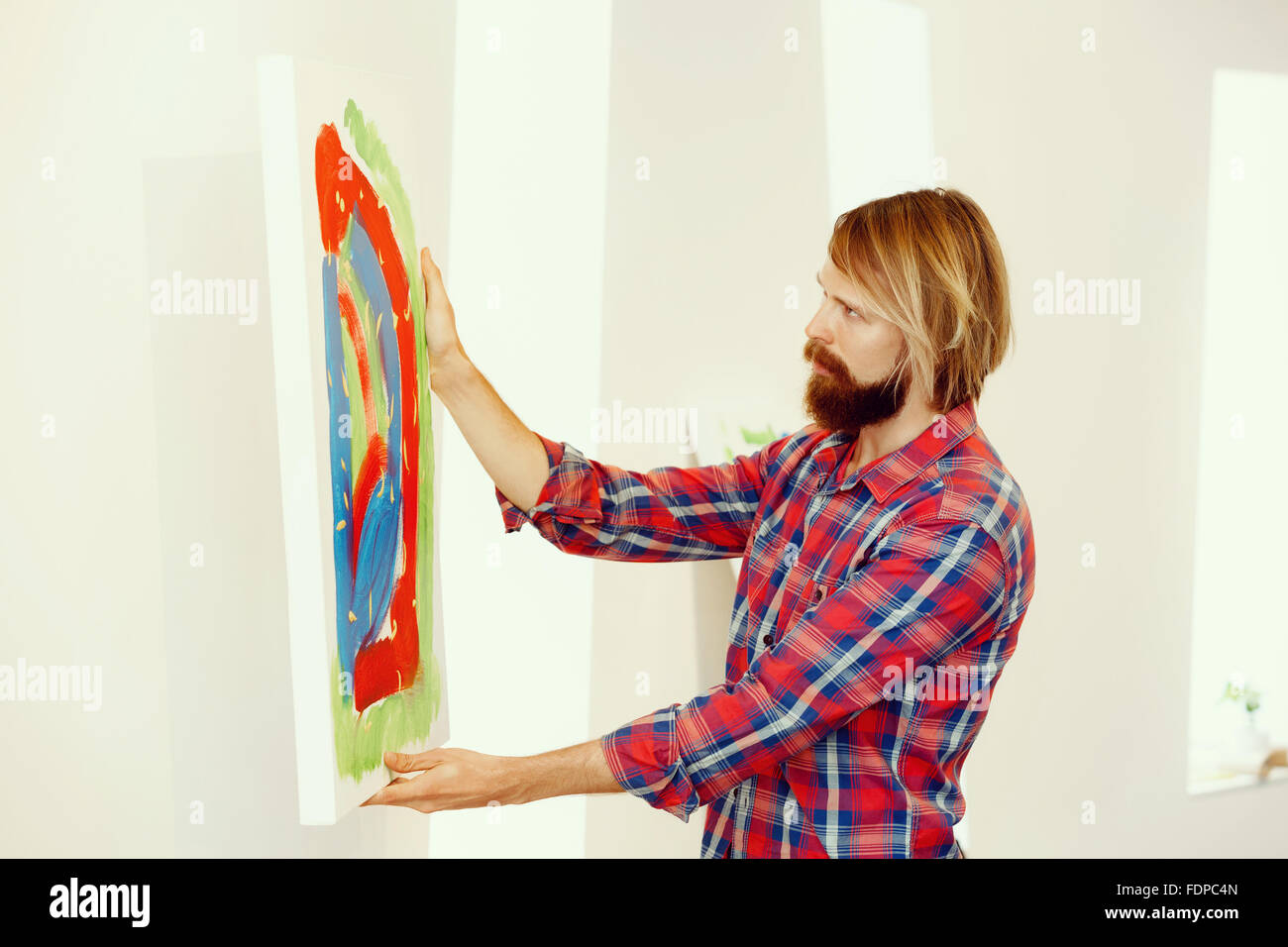 Young male artist standing with his picture Stock Photo - Alamy