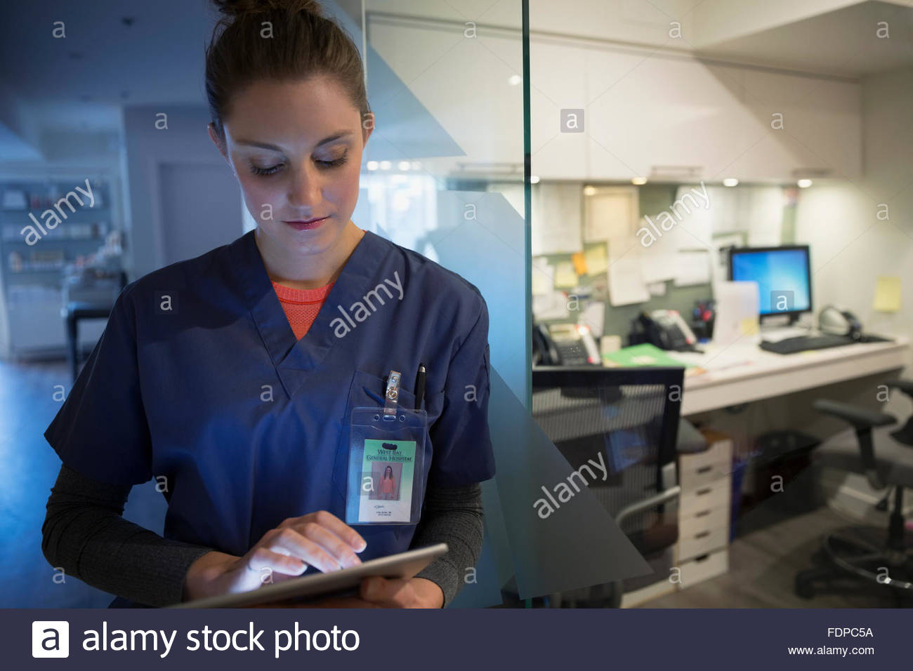 Nurse using digital tablet at nurses station Stock Photo - Alamy