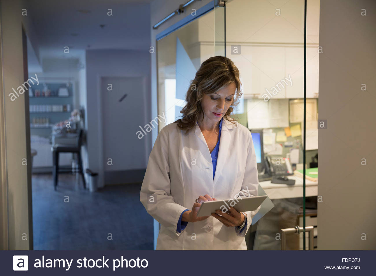Doctor using digital tablet at nurses station Stock Photo - Alamy