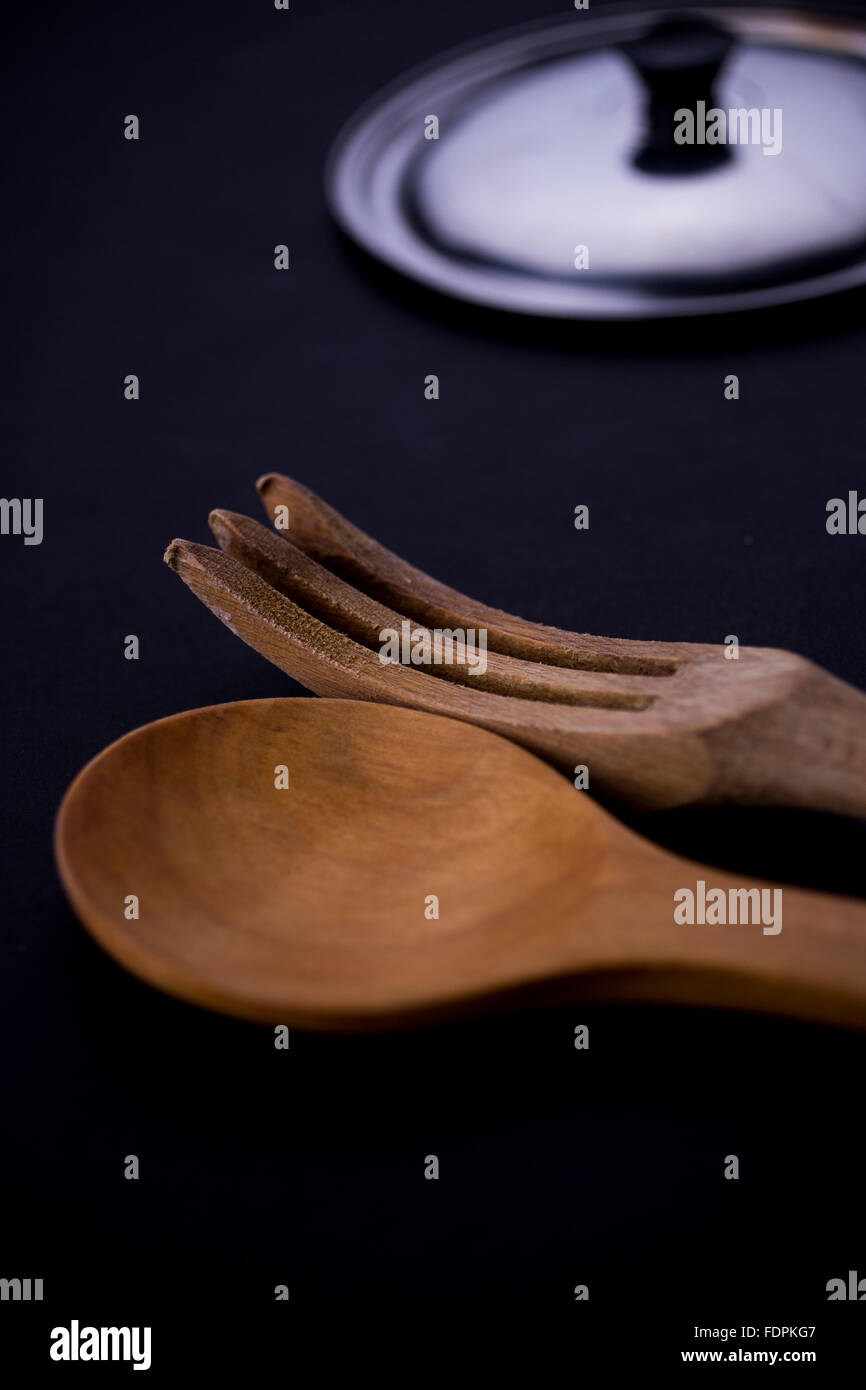 Still life of wooden carved cutlery isolated on black Stock Photo - Alamy