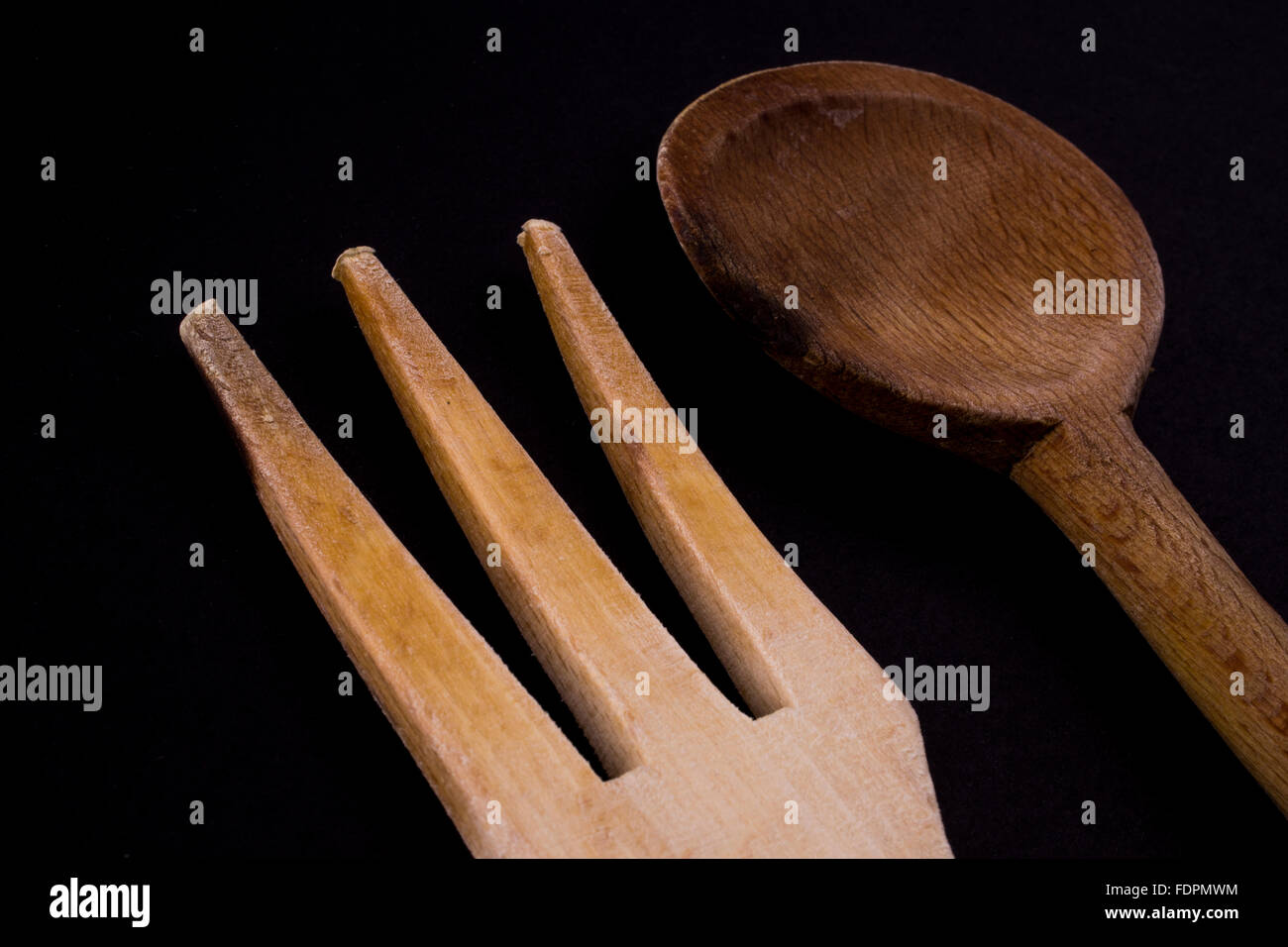 Still life of wooden carved cutlery isolated on black Stock Photo - Alamy
