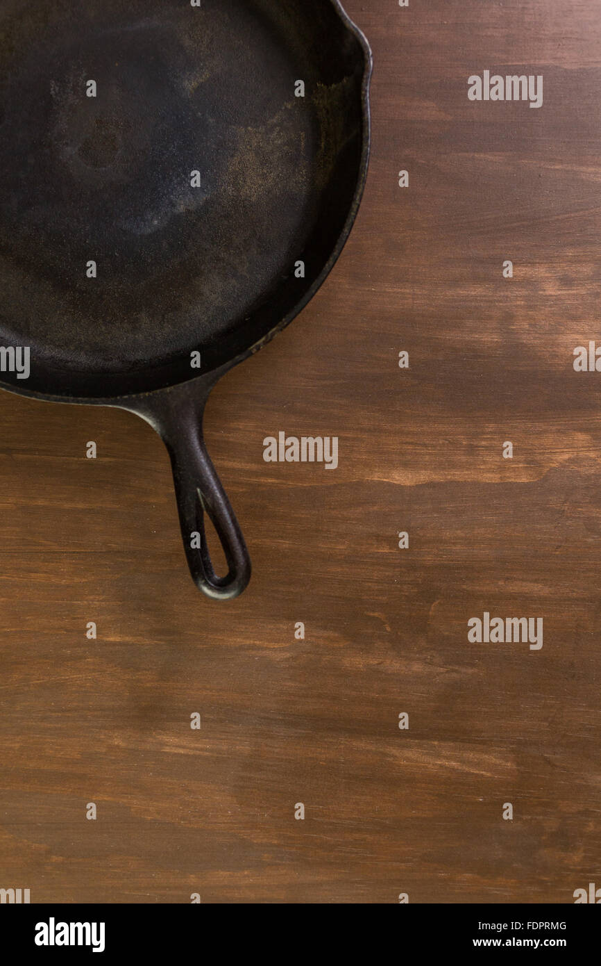 Cast iron skillet on rustic wood table Stock Photo - Alamy