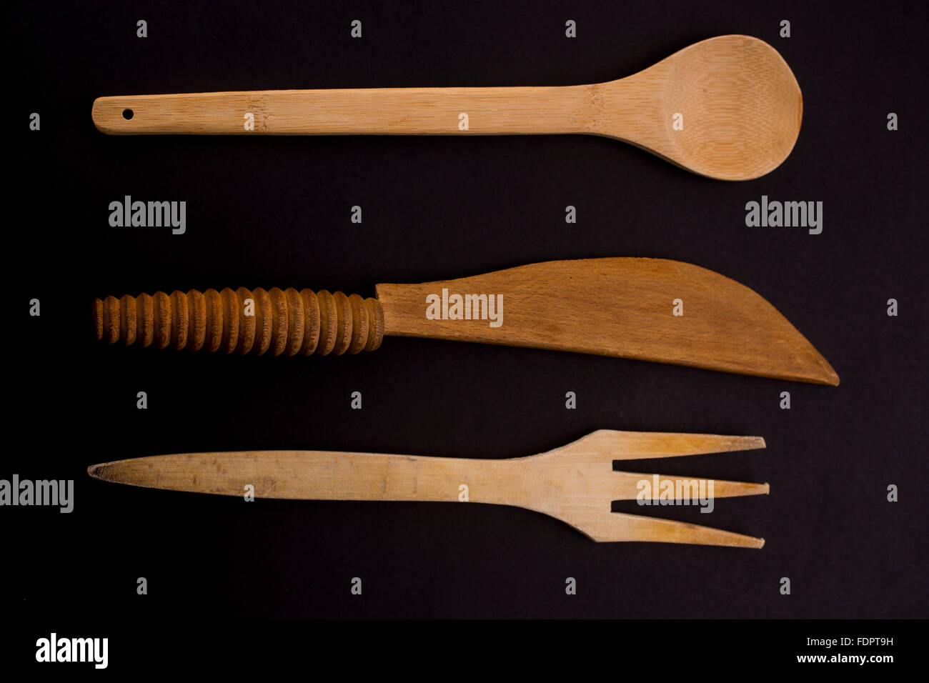 Still life of wooden carved cutlery isolated on black Stock Photo - Alamy